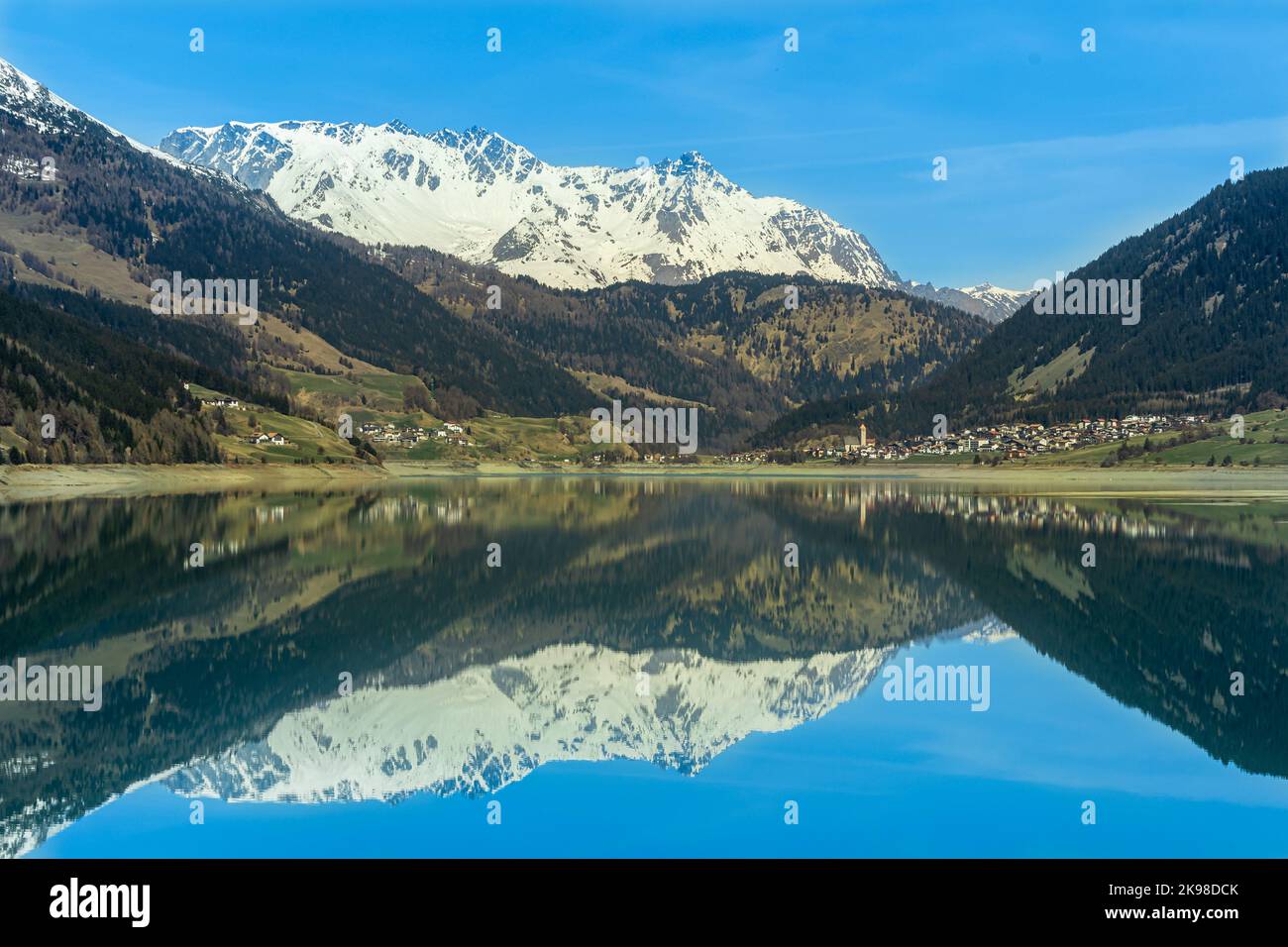 Panoramic view of the lake in the mountains. With the village of Resia ...