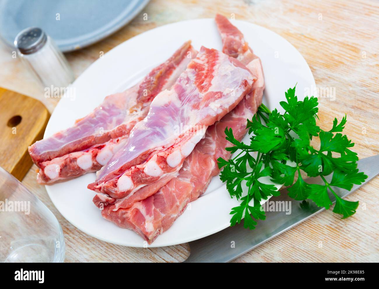 Unprepared pork ribs chopped and ready-to-cook served on white plate ...