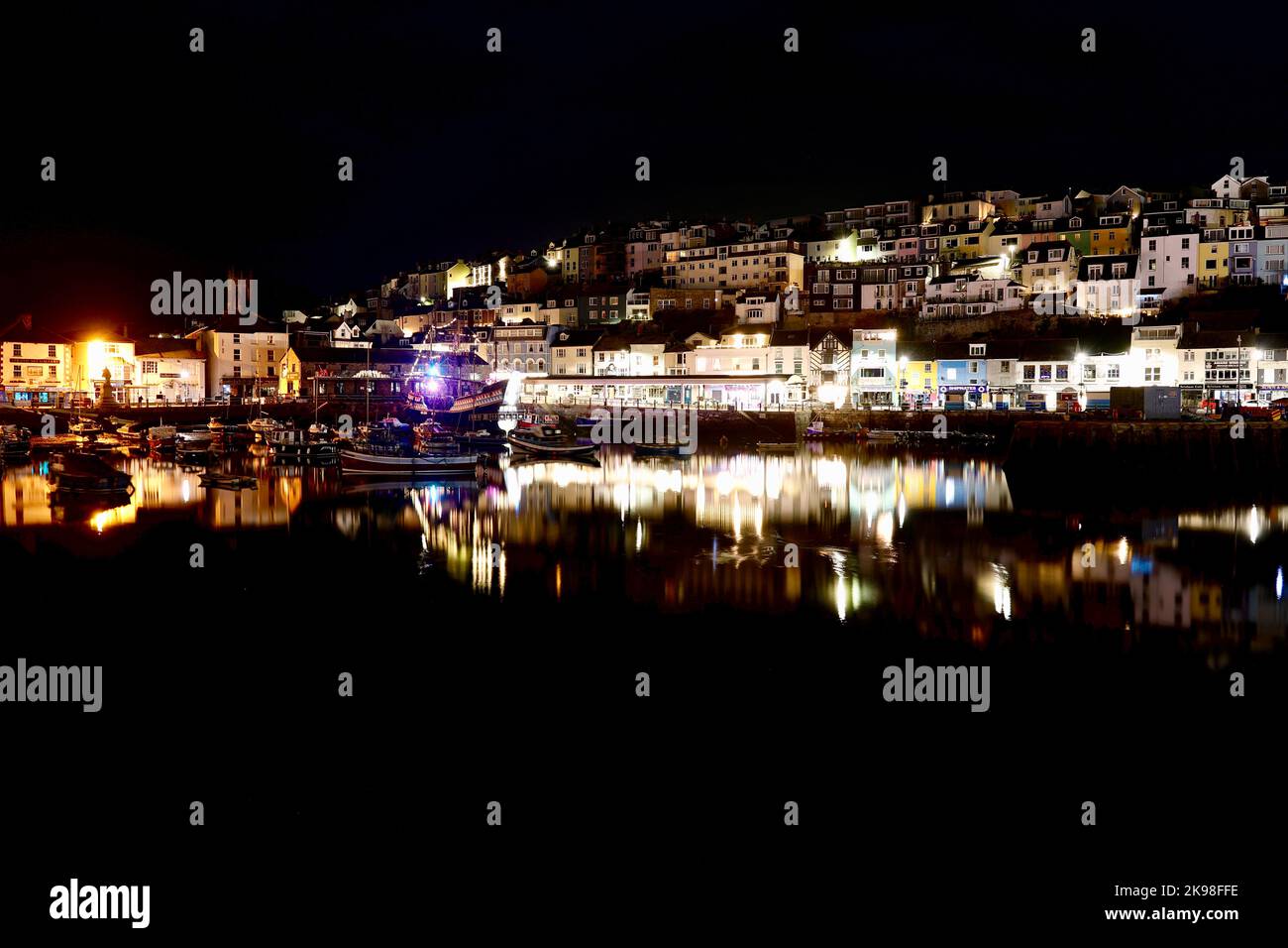 Night time view across the inner harbour at Brixham, a fishing town on ...
