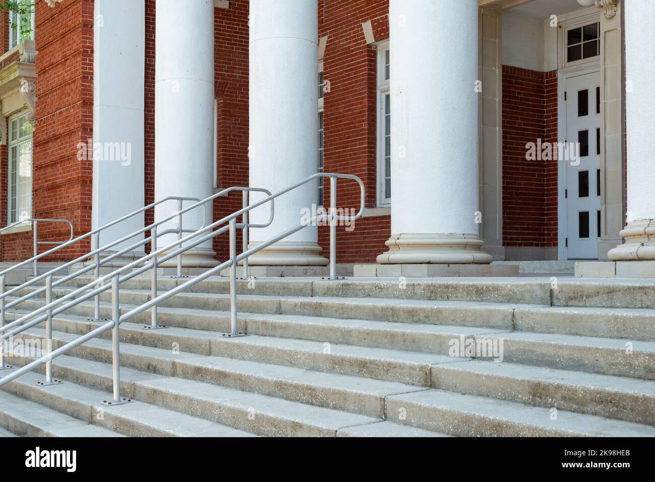 Four large white round columns at the facade entrance to a red vintage ...