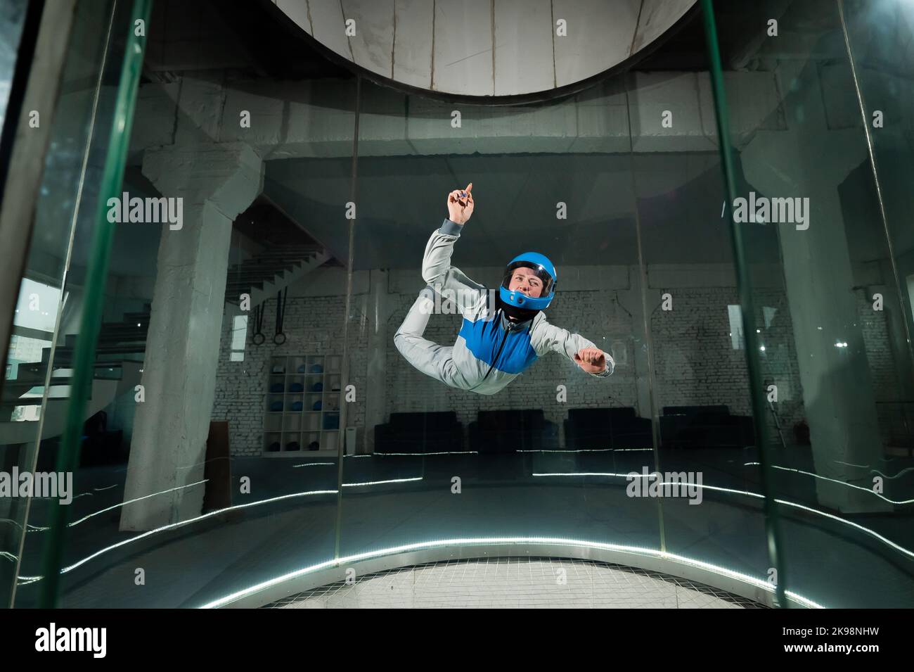 A woman flies in a wind tunnel. Free fall simulator Stock Photo - Alamy