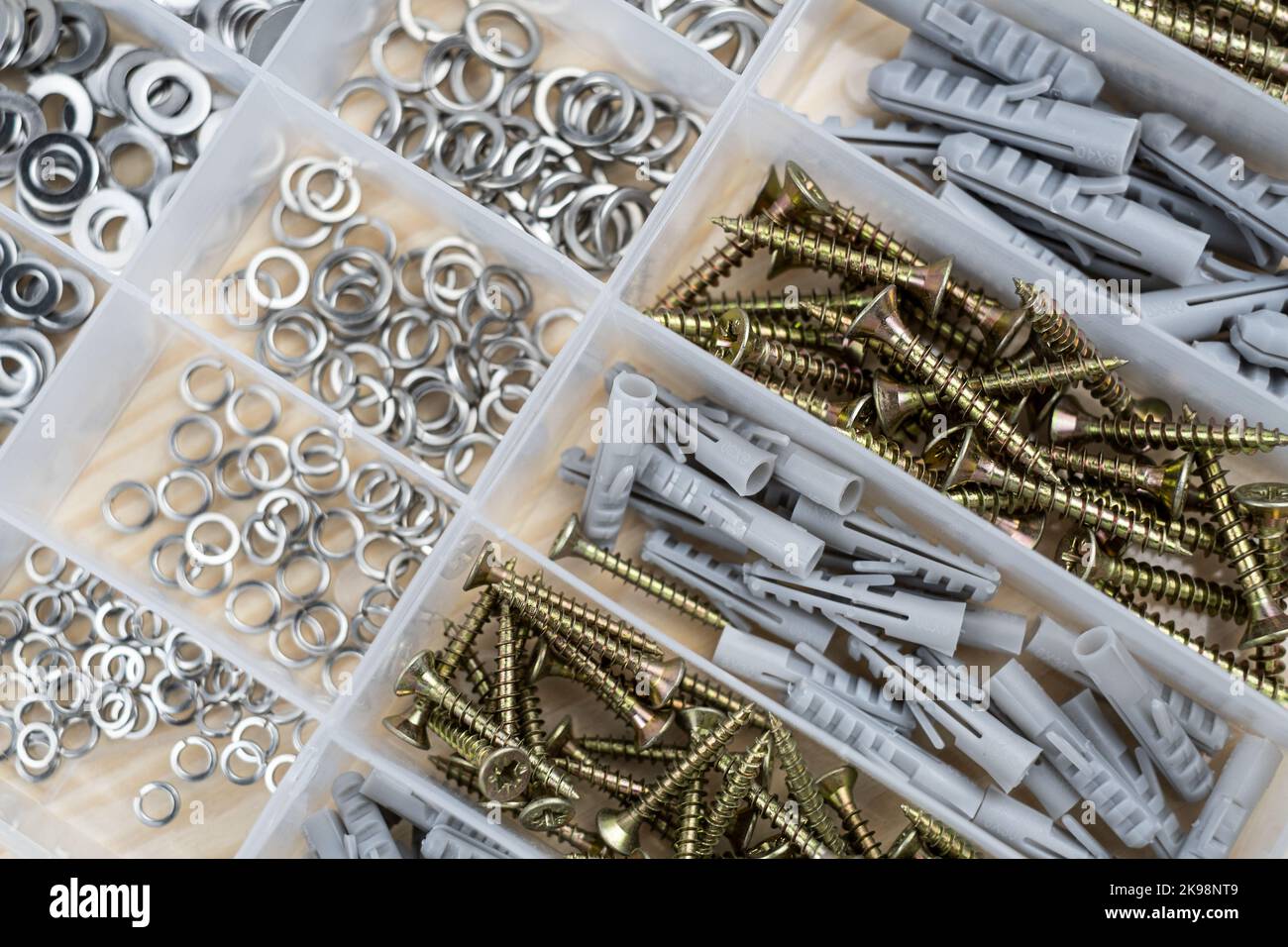 Screws and dowels of various sizes in A transparent plastic box ...