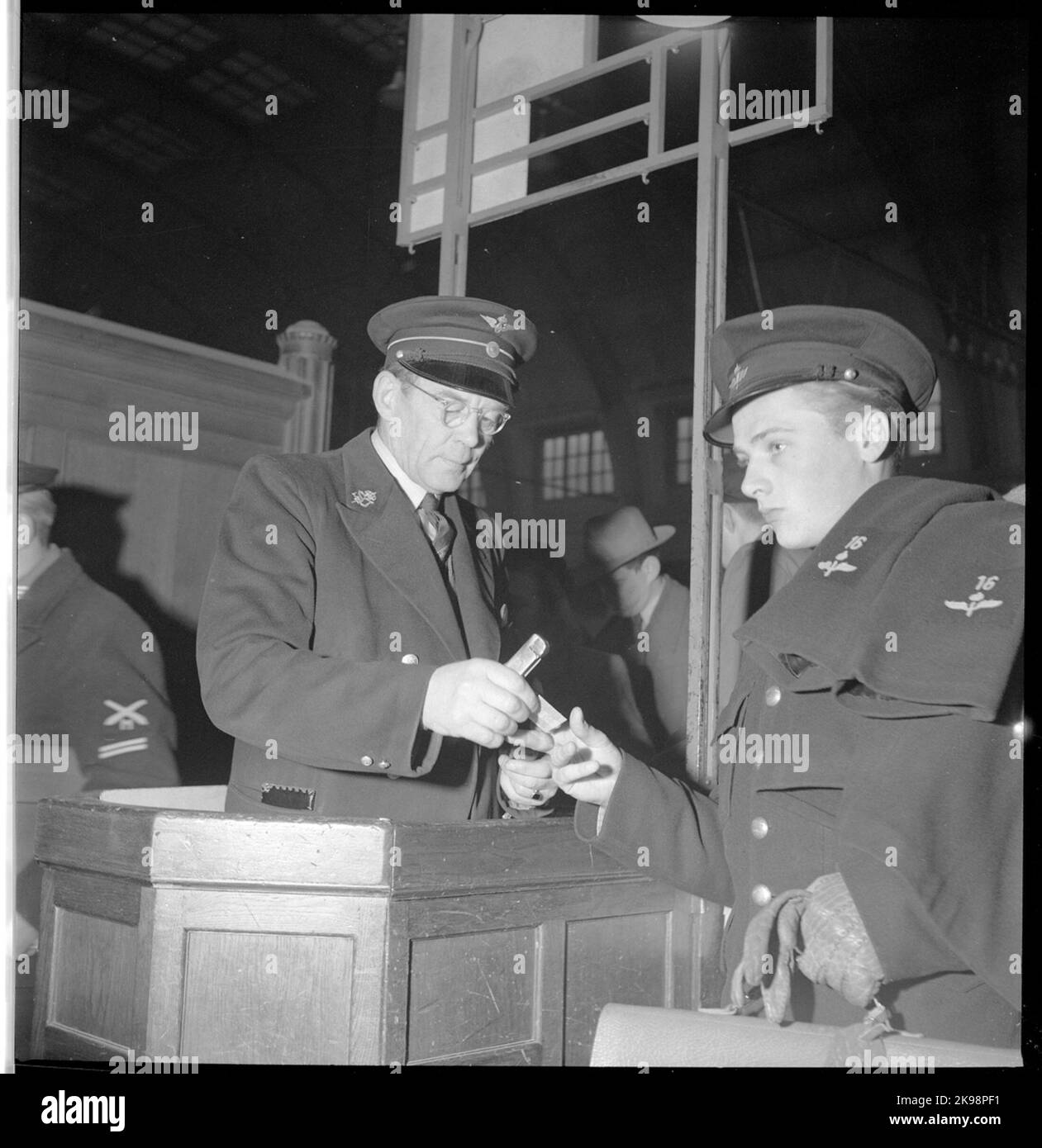 Conductor cuts tickets Stock Photo - Alamy