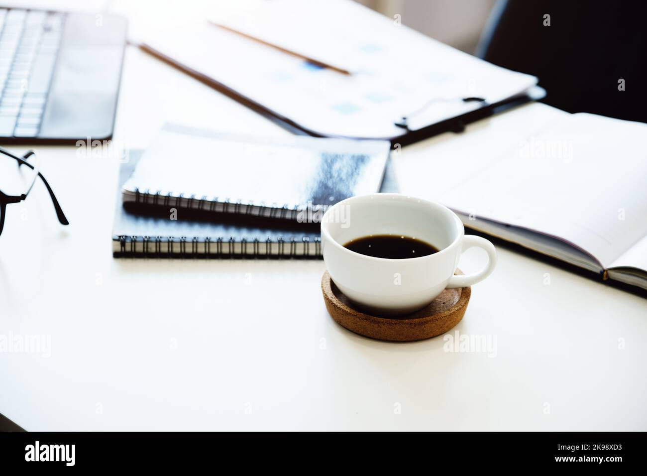 Focus on coffee mugs with books, documents with tablet computers on the ...