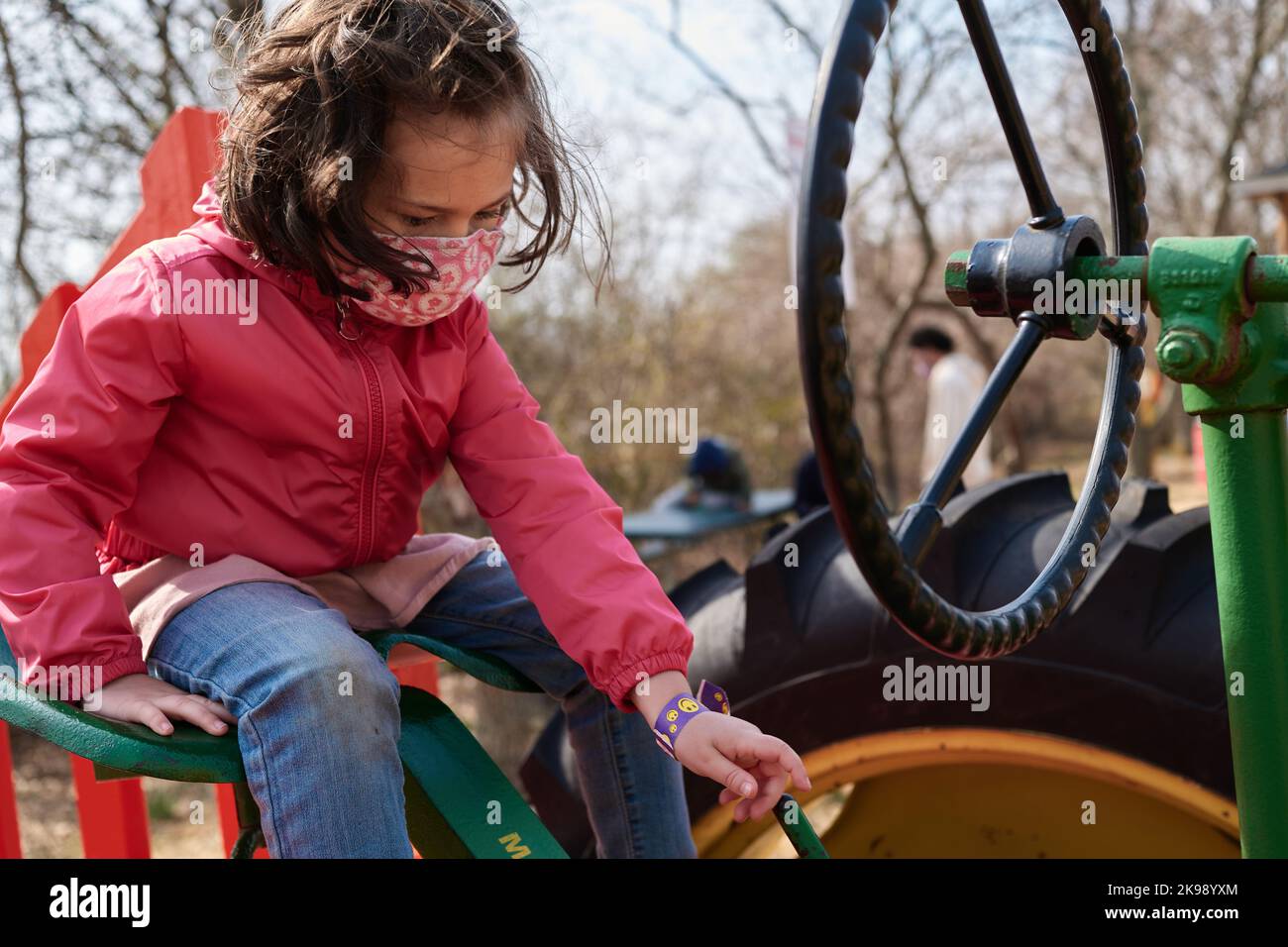 little girl wearing a mask pretending to drive the tractor exhibit at ...