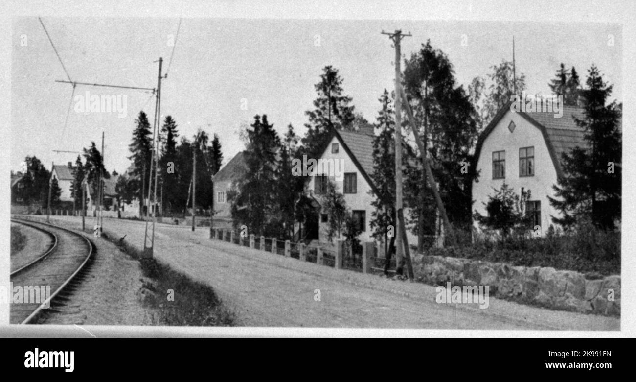 Three residential buildings in a row to the right and tram to the left ...