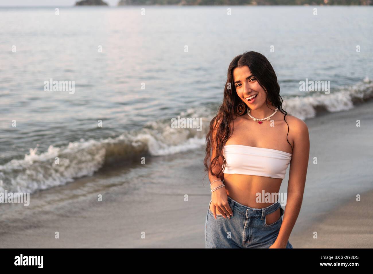 Portrait of a beautiful diverse latina woman smiling on the beach. Hispanic lifestyle concept ...