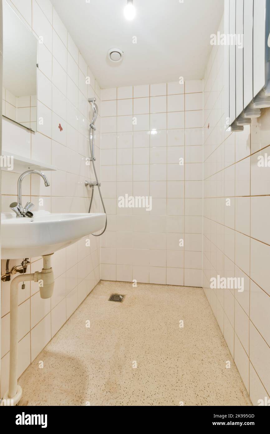 Interior of shower room with hose and tap on shabby concrete walls and ...