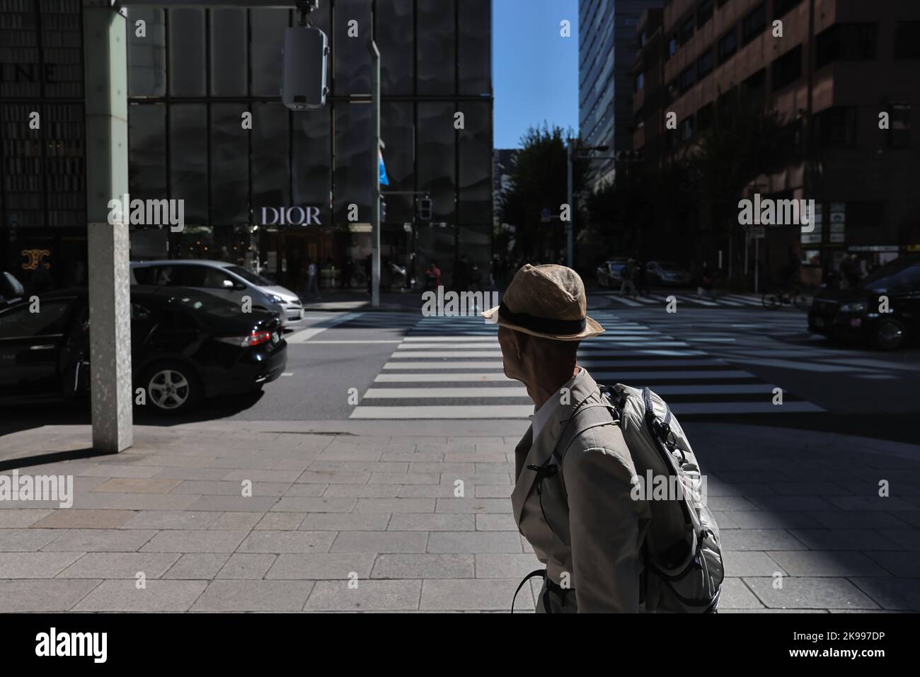 Pedestrian looks towards the Dior flagship store in Ginza, Tokyo during ...