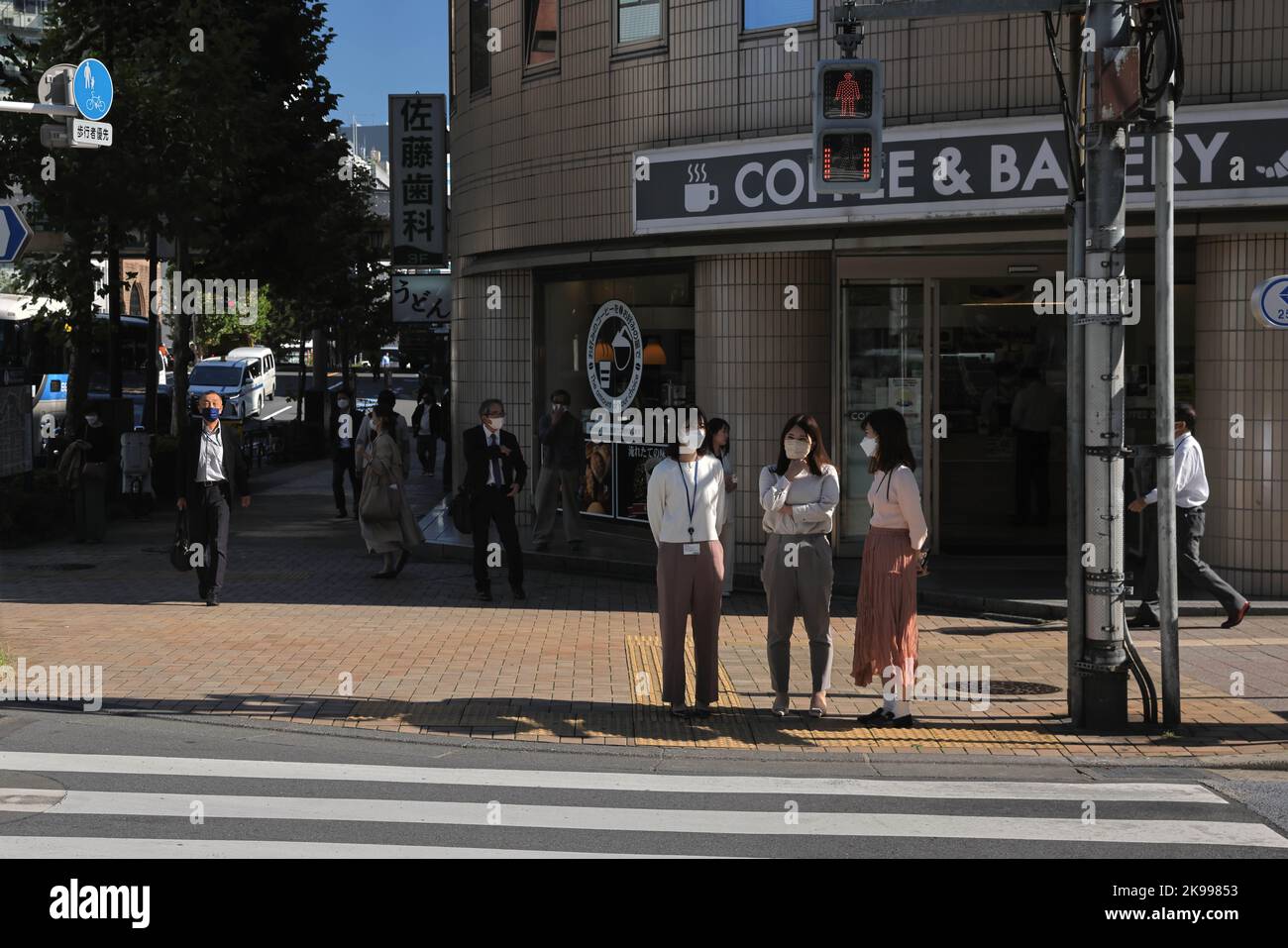 Tokyo, Japan. 20th Oct, 2022. Office workers wait at a traffic light to ...