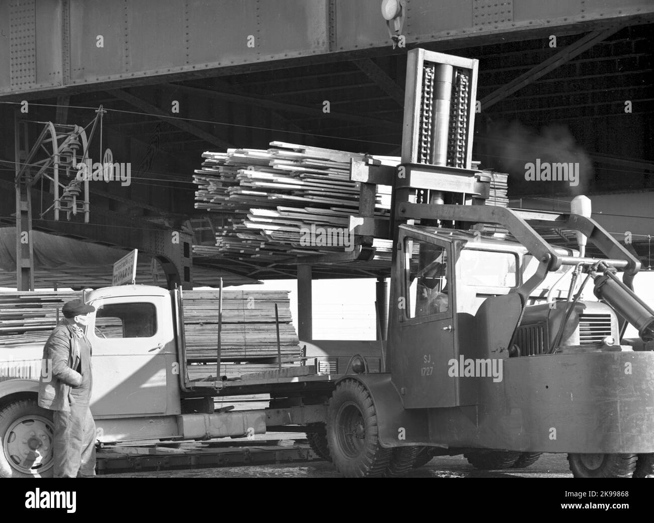 Larger forklift in quay service, Liljeholmen. Loading of wood on truck ...
