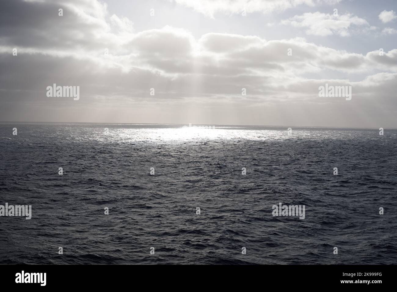 sunlight breaking through the clouds in the middle of the ocean Stock ...