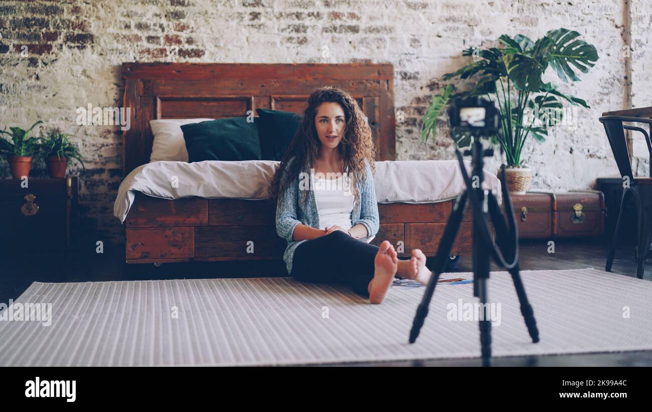 Attractive young woman with long curly hair blogger is recording video ...