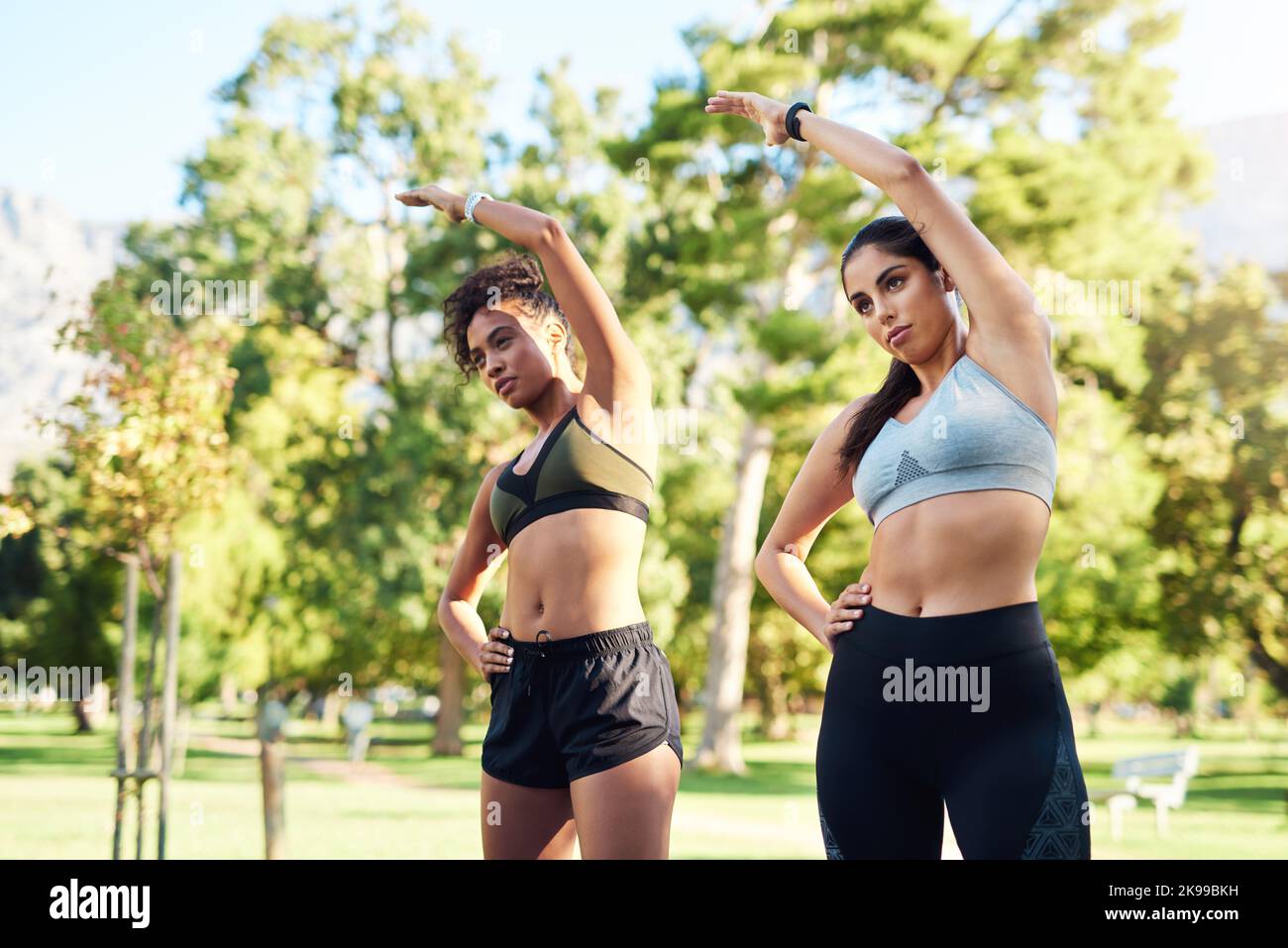 Stretch it out. two attractive young women stretching next to each ...