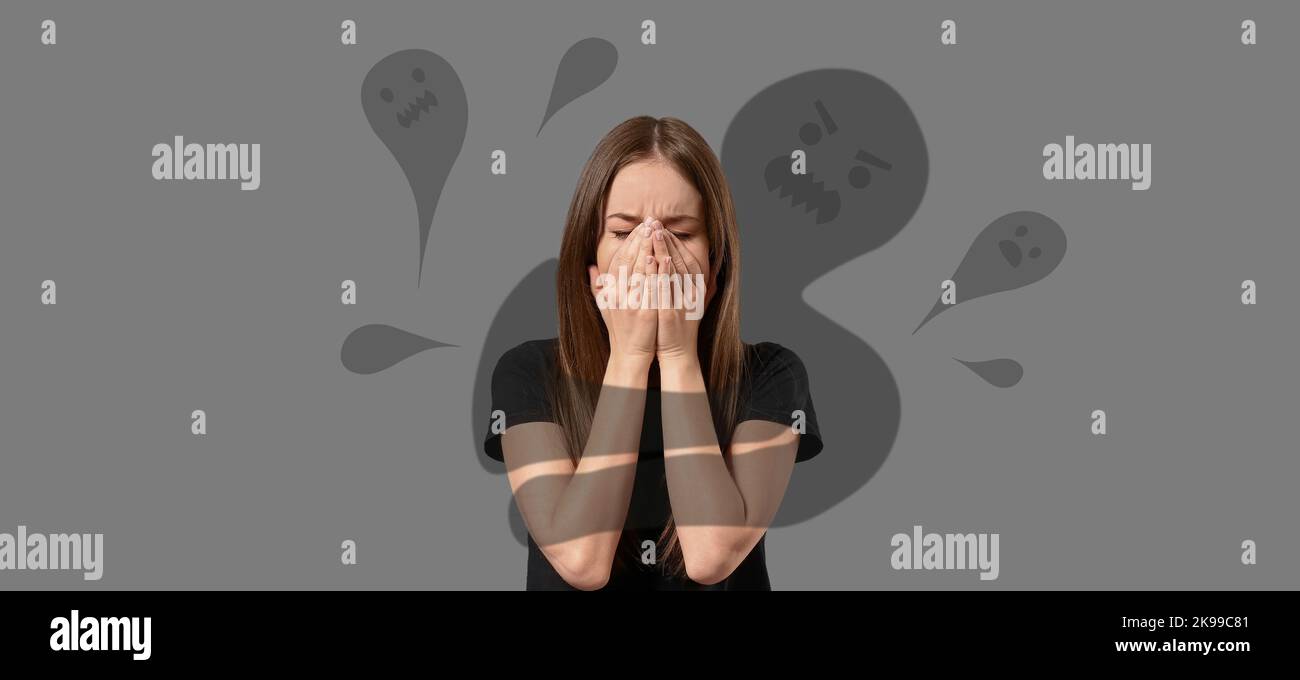 Stressed young woman having panic attack and monsters on grey ...