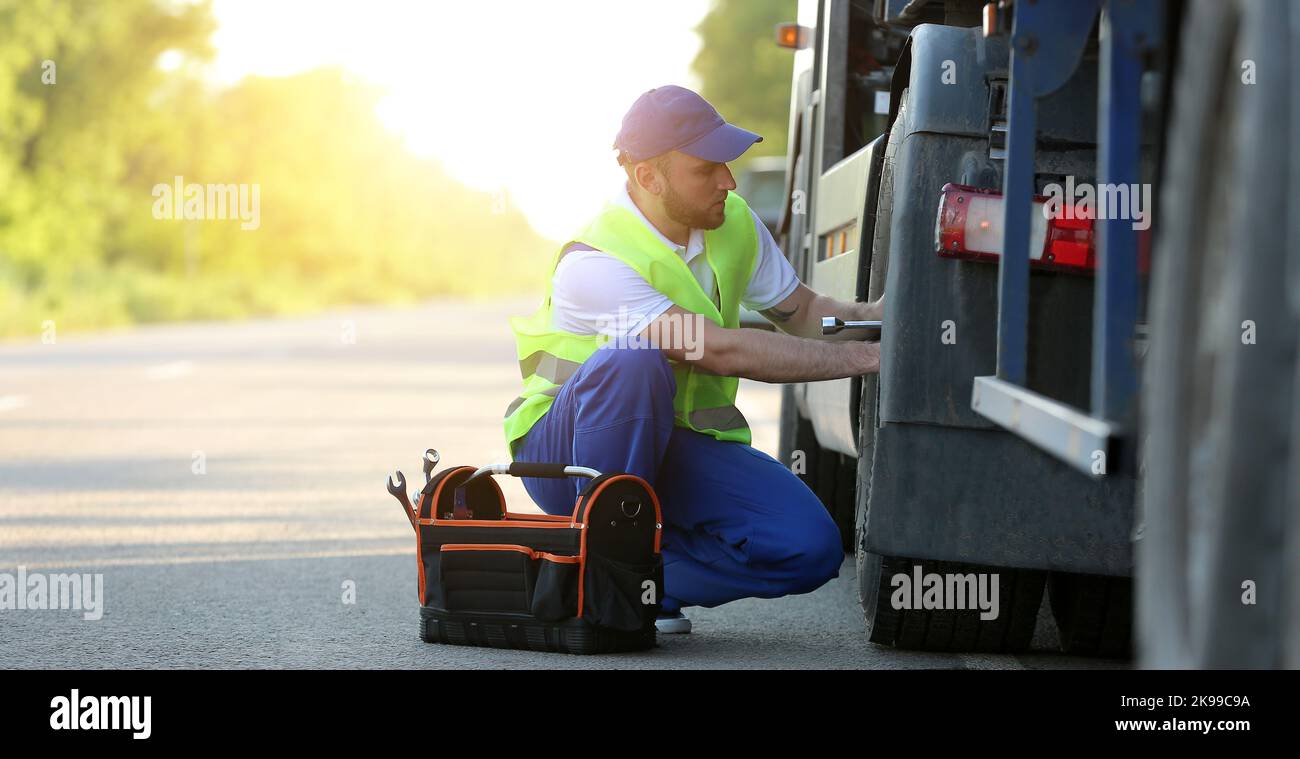 Male driver fixing big truck outdoors Stock Photo - Alamy