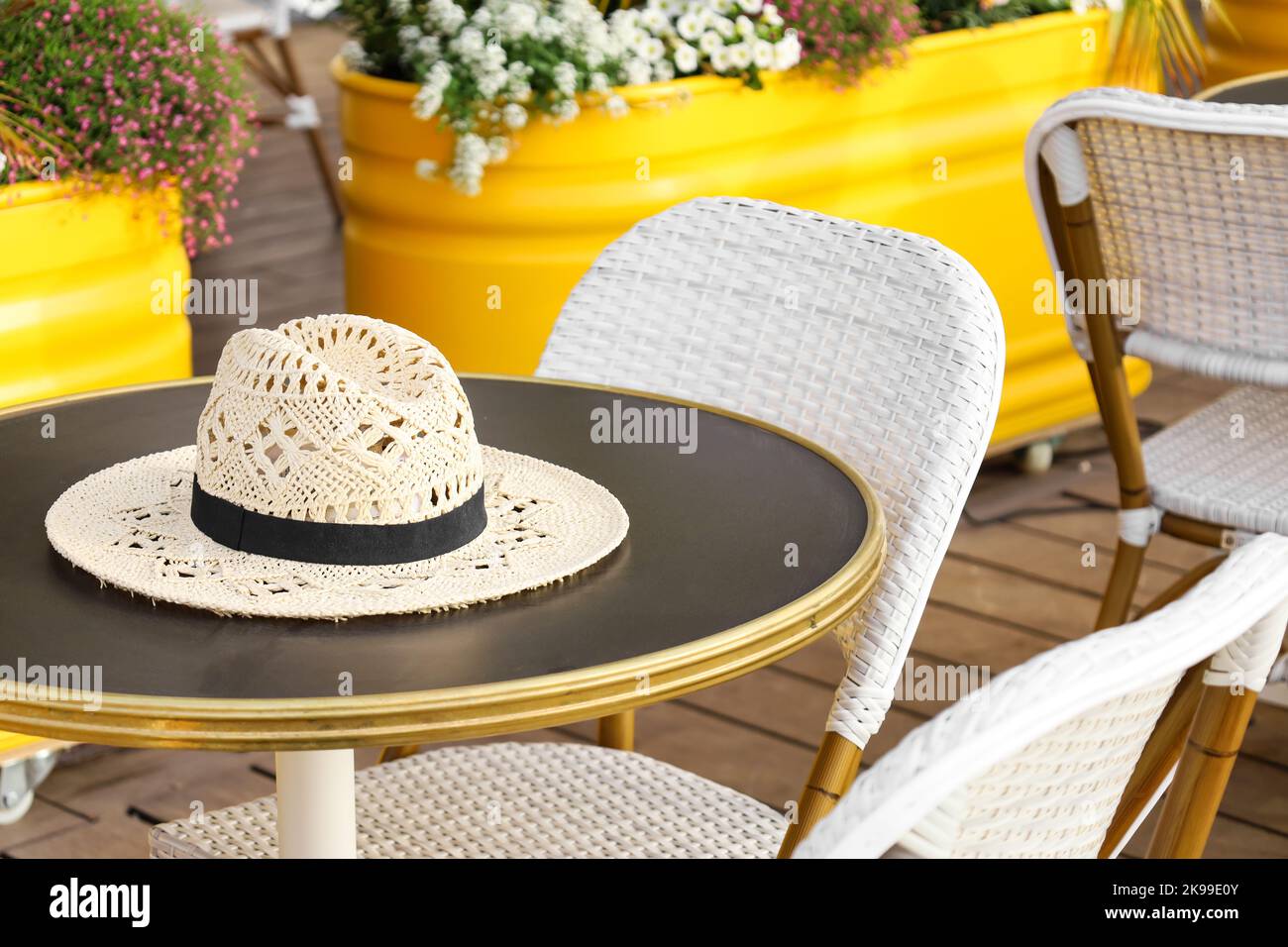 Stylish hat on table in outdoor cafe Stock Photo - Alamy