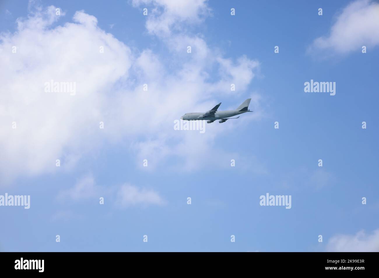 Modern airplane flying in blue sky Stock Photo - Alamy