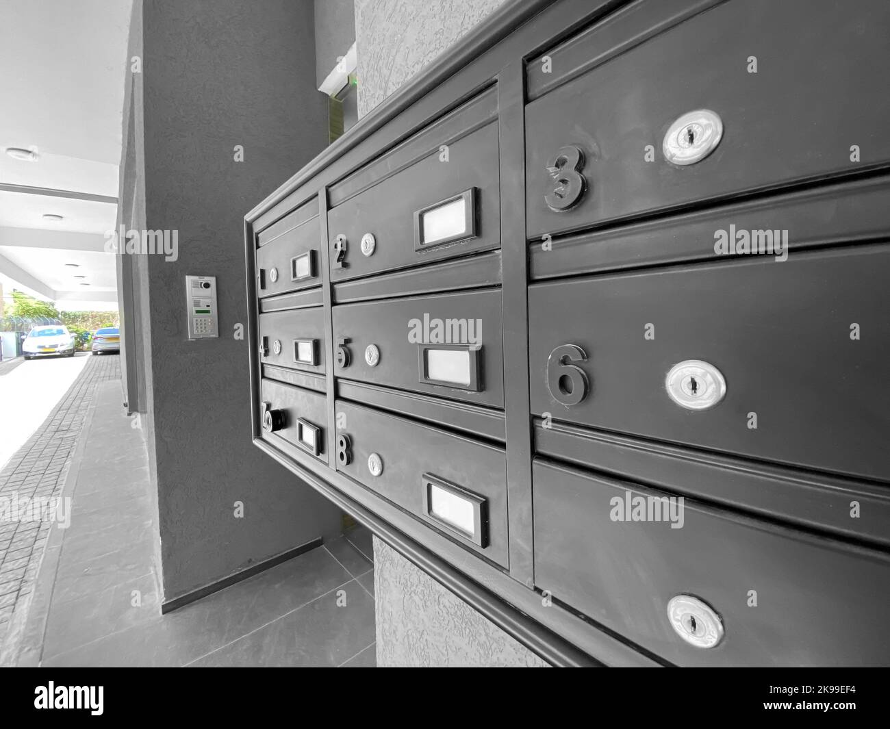 Closeup view of modern mailboxes on grey wall in residential building ...
