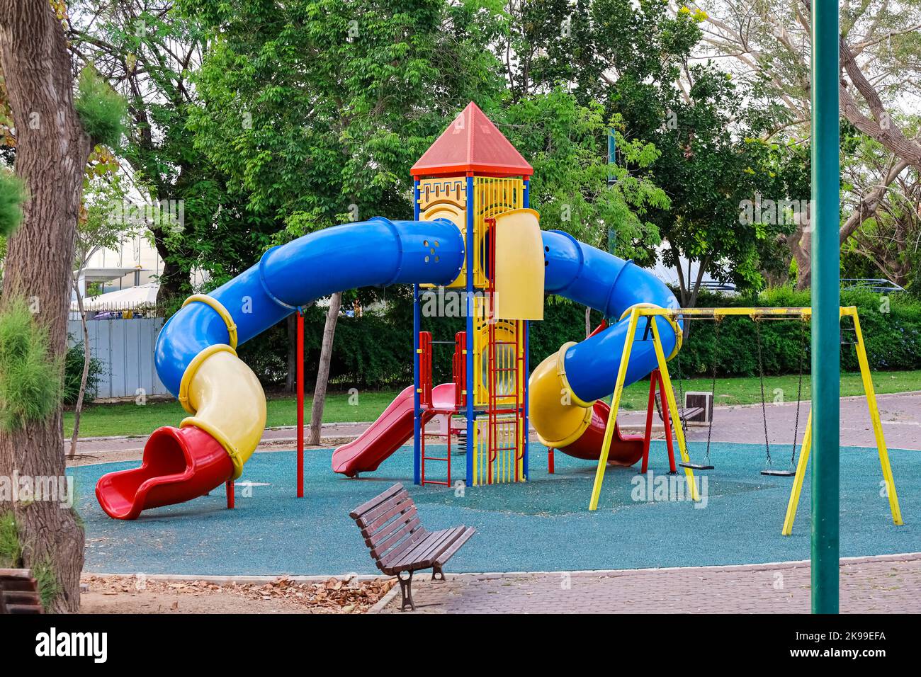 View of children's playground with slide and swings in city Stock Photo ...