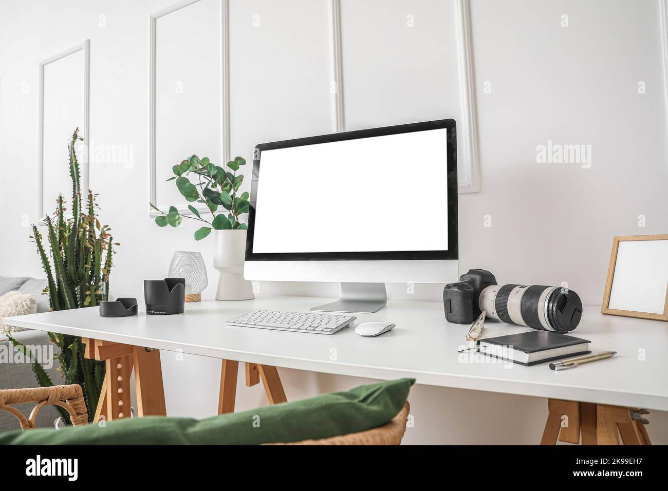 Photographer's workplace with computer and equipment in light office ...
