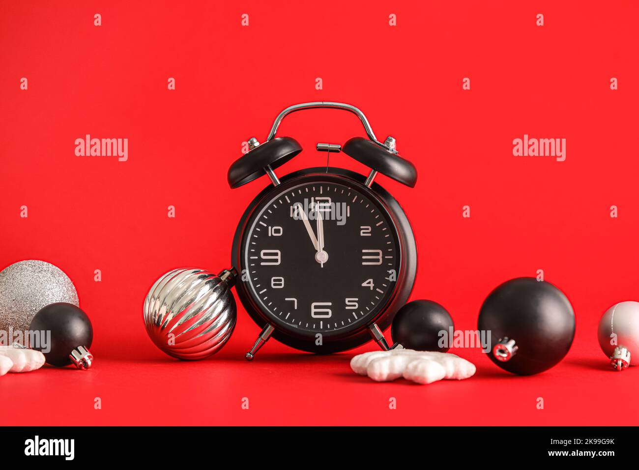 Alarm clock with Christmas balls on red background Stock Photo - Alamy