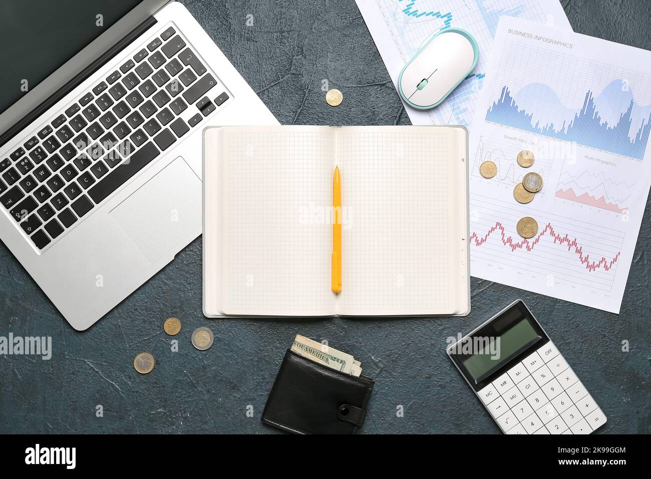 Notebook with diagrams, laptop, money and calculator on dark background ...