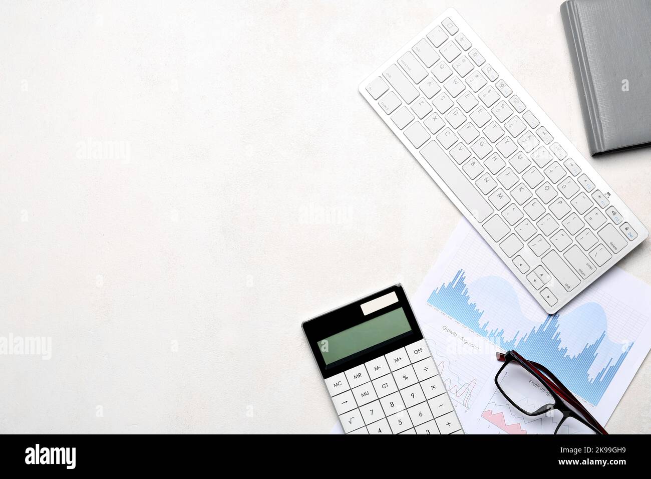 Computer keyboard, diagrams, calculator and eyeglasses on white ...