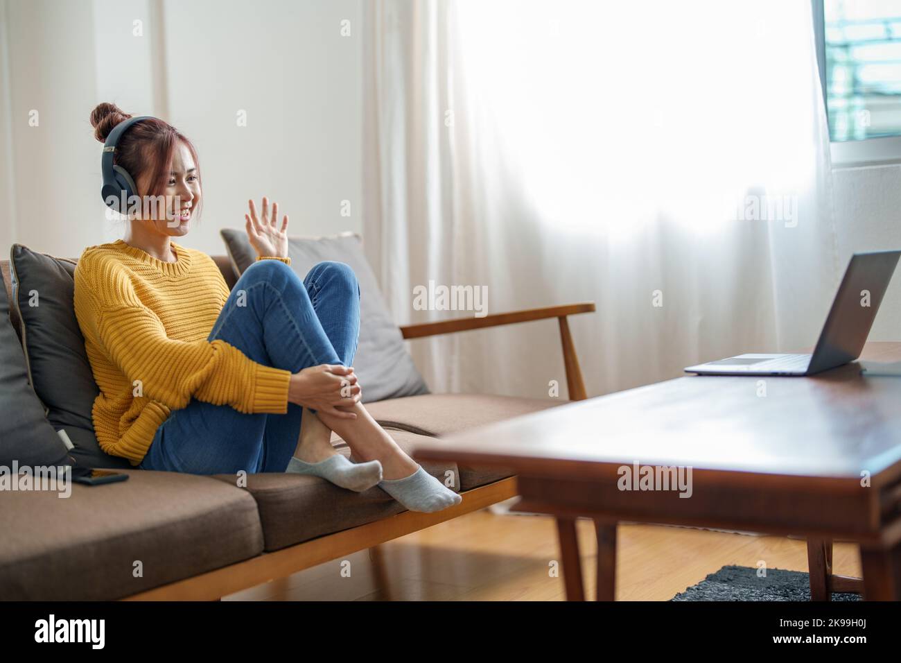 Portrait of a young Asian woman sitting with a smiling face using a ...