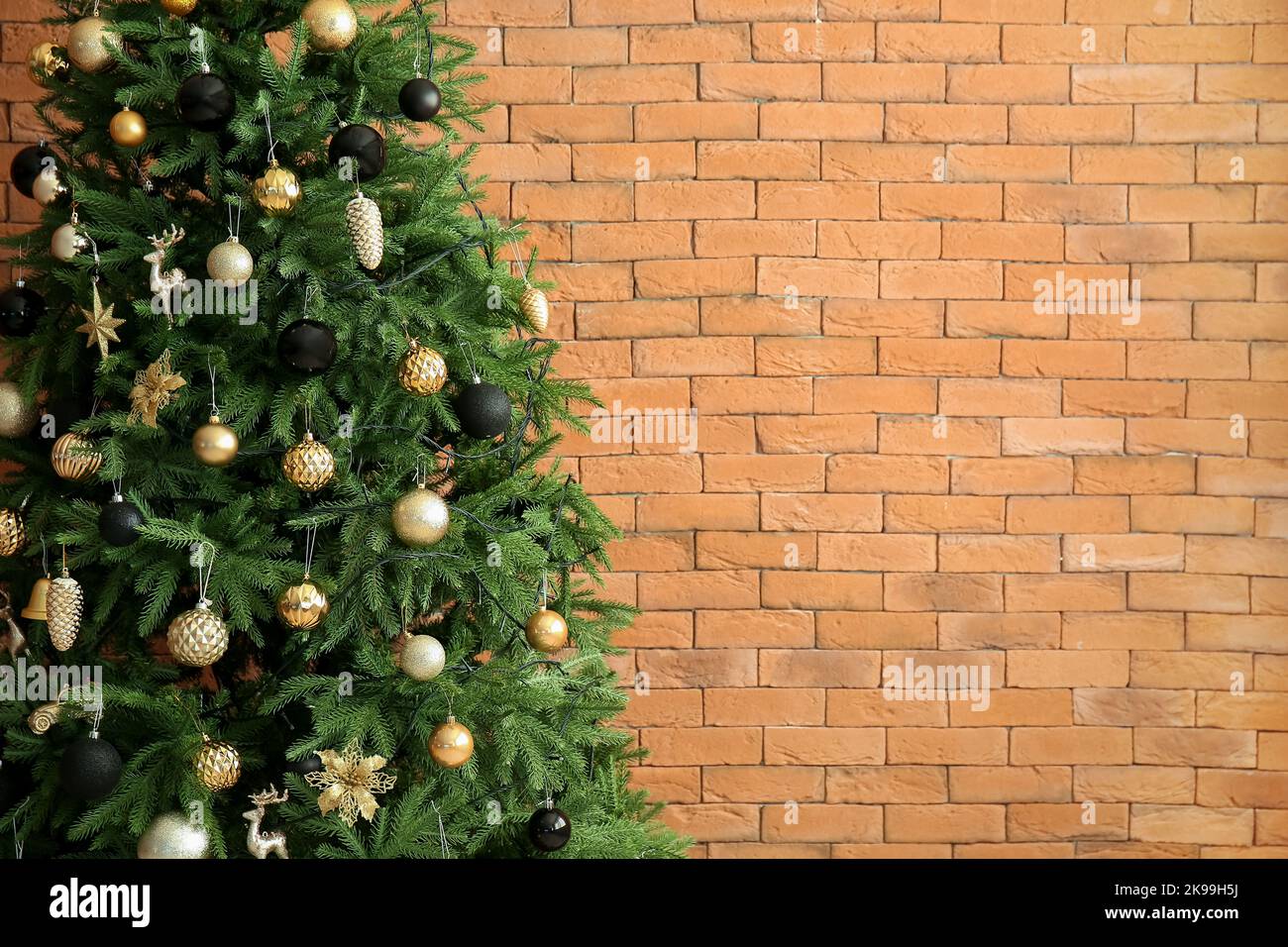 Big Christmas tree near brick wall Stock Photo - Alamy