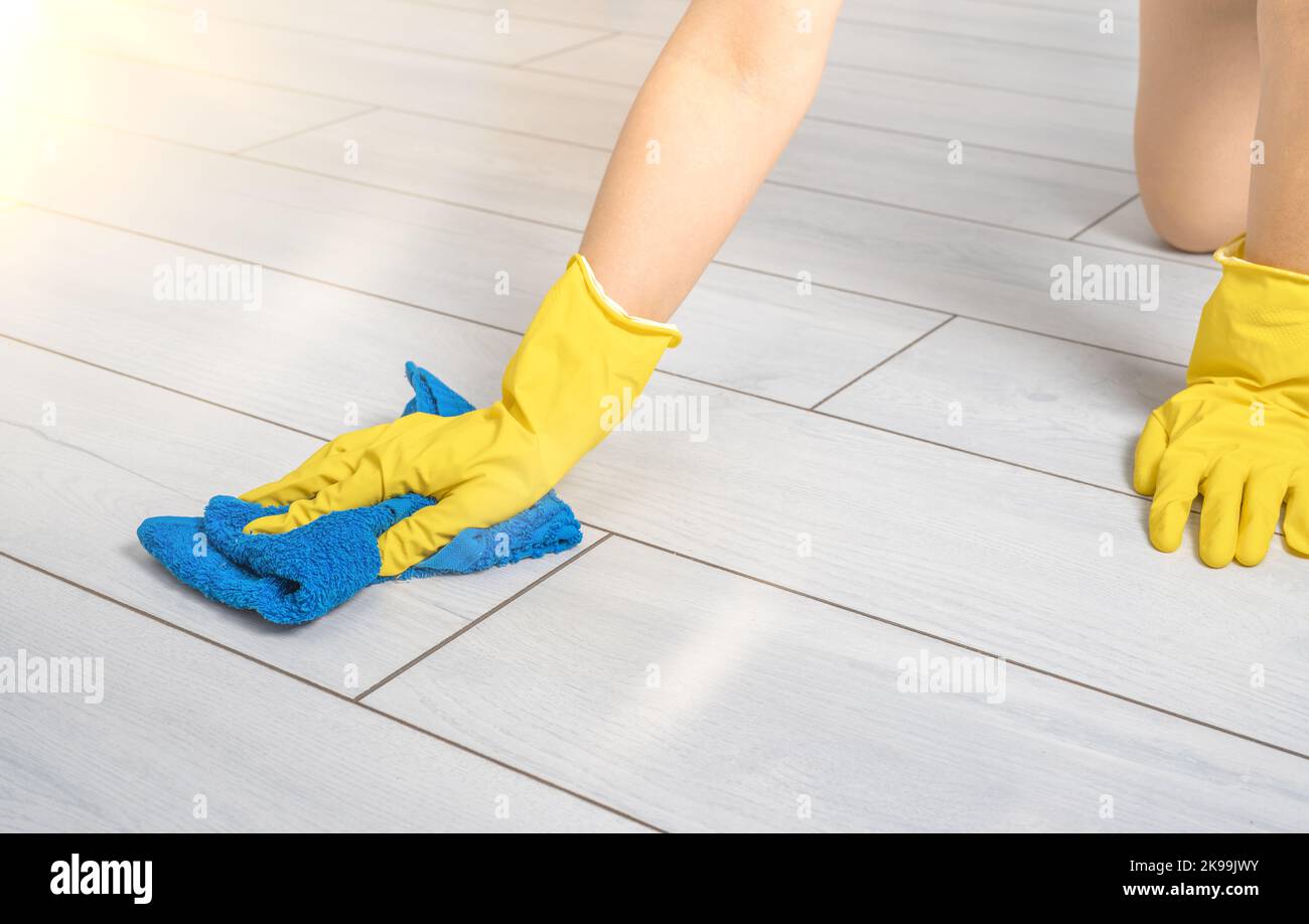 Cleaning service. female hands in gloves wipe white floor with blue ...