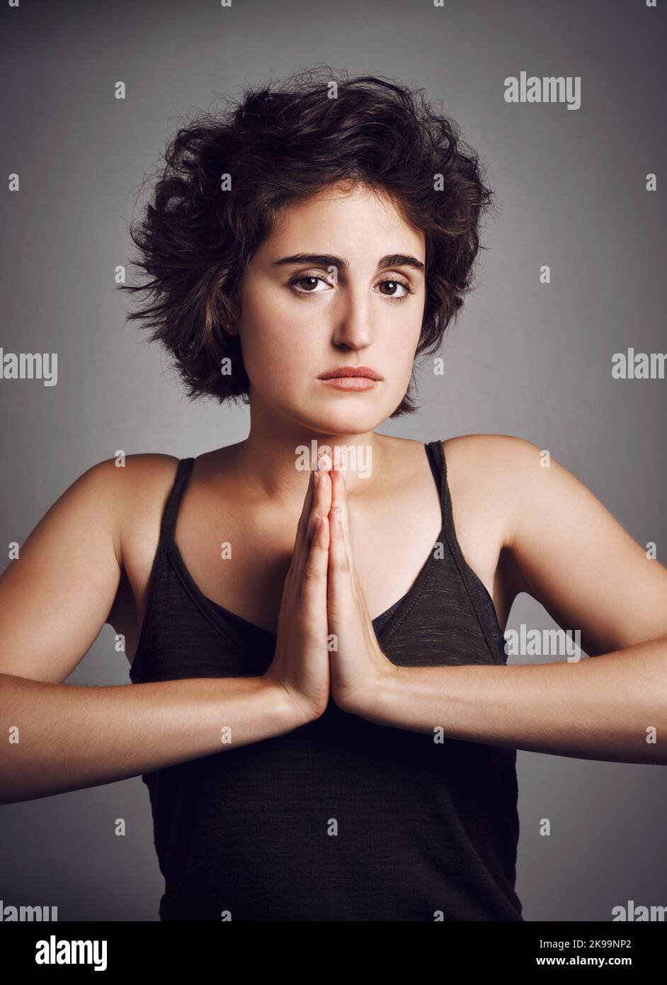 Maybe prayer might work. Studio portrait of an attractive young woman ...