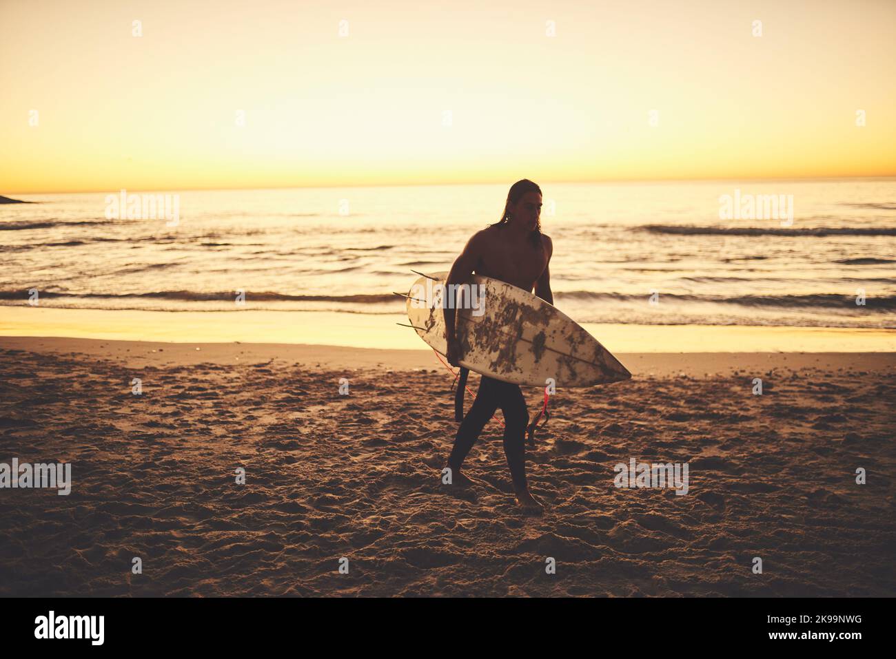 Catch you on the surfy side. a young man carrying a surfboard at the ...