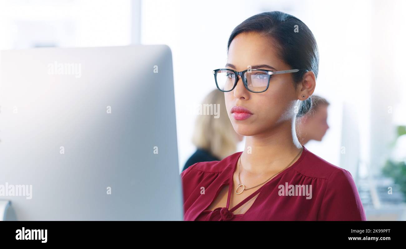 Dont bug her while shes busy. a focused young businesswoman working on ...