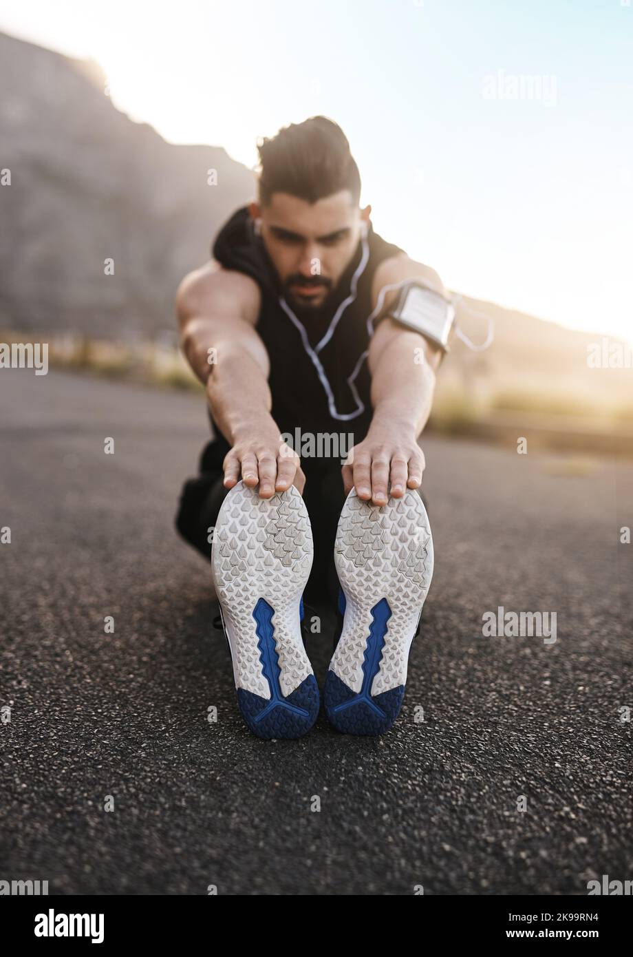 Youve got to reach for your goals. a sporty young man exercising ...