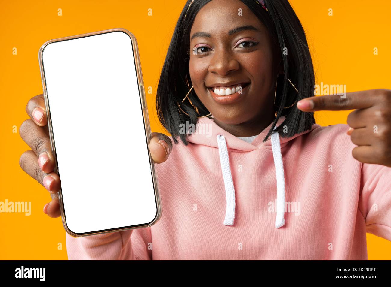 Portrait of a excited young african woman showing blank screen mobile ...