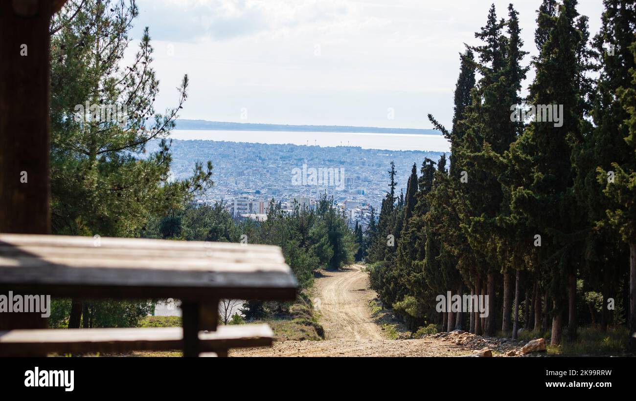 A wooden bench and a narrow path going down to the beach an city Stock ...