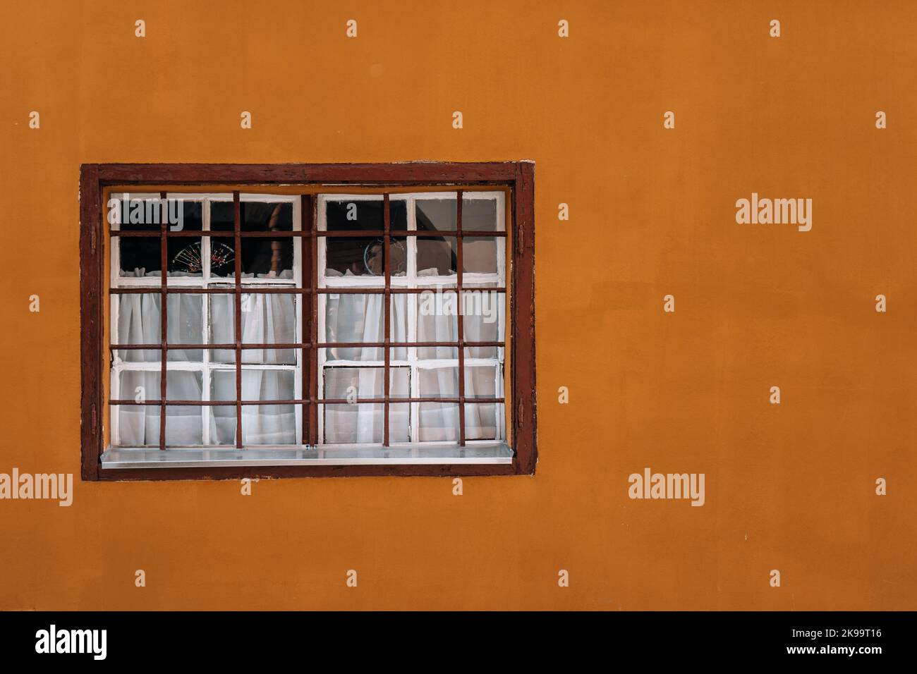 A bright orange building wall with a window Stock Photo - Alamy