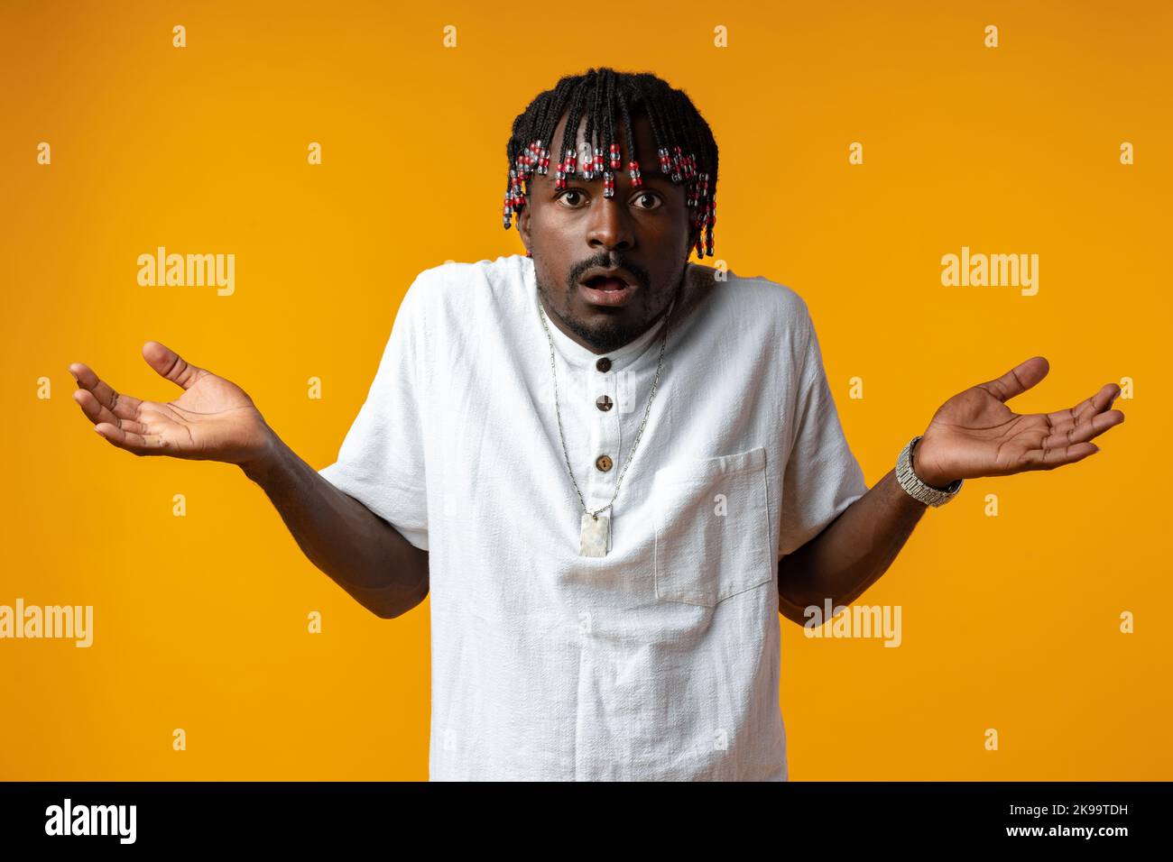 Young afrcian man on yellow background showing helpless gesture with ...