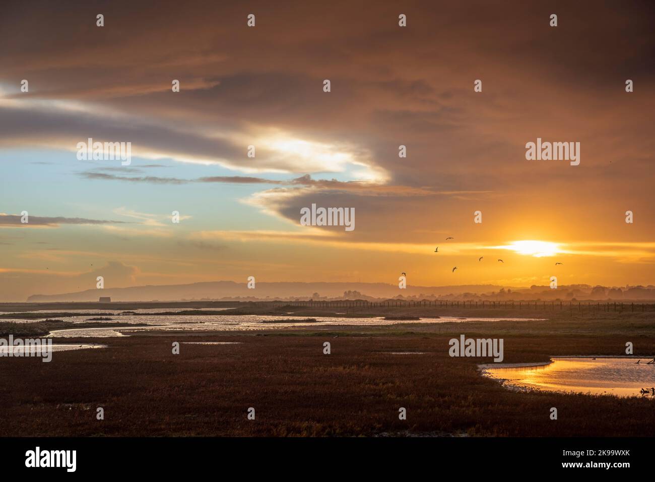 Moody stormy colourful sunset skies over Rye Harbour nature reserve on ...