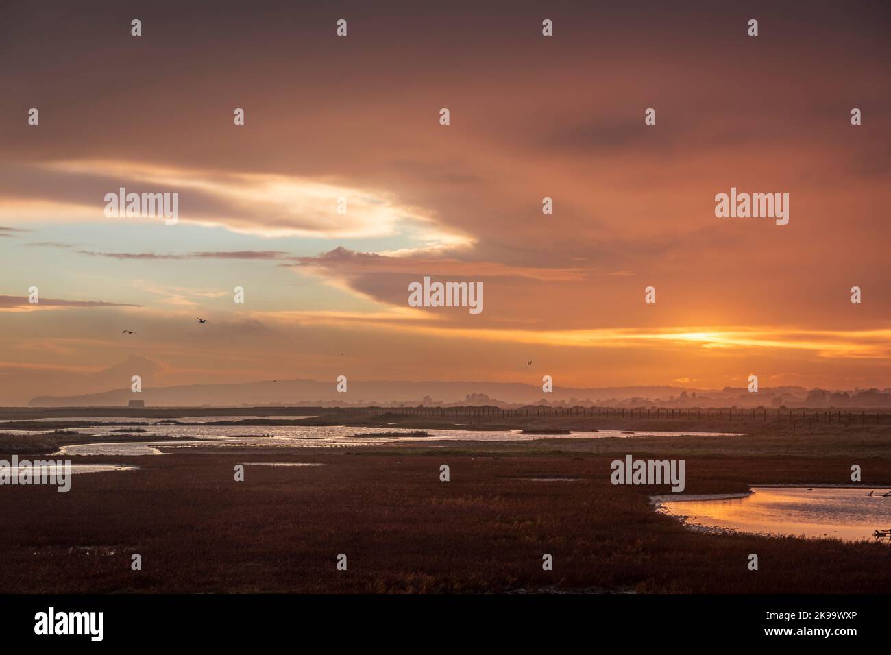 Moody stormy colourful sunset skies over Rye Harbour nature reserve on ...