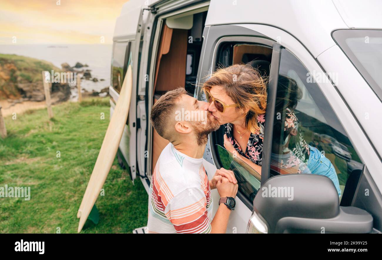 Couple kissing through the camper van window during a trip Stock Photo ...