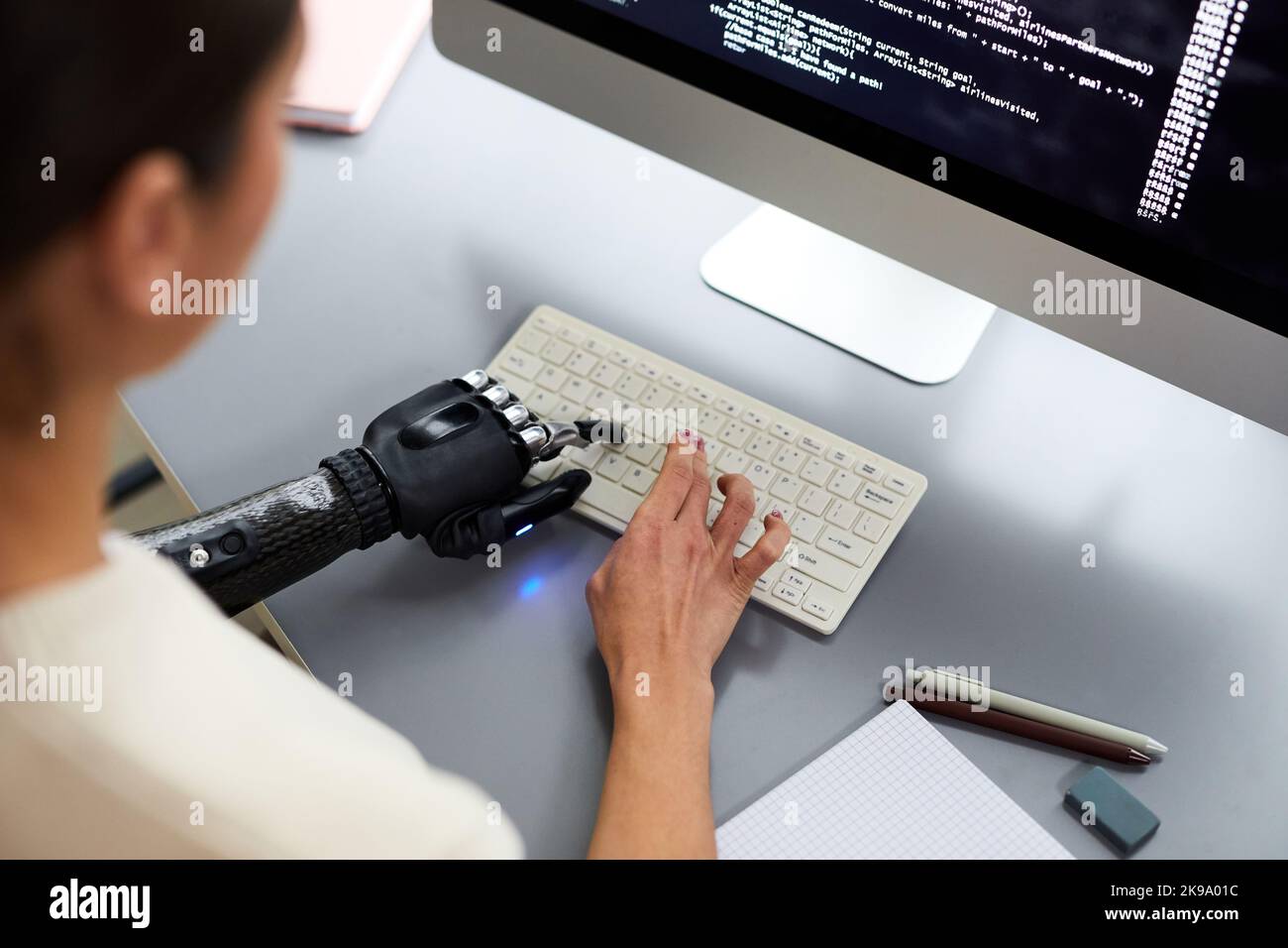 High angle view of woman with disability writing codes on computer ...