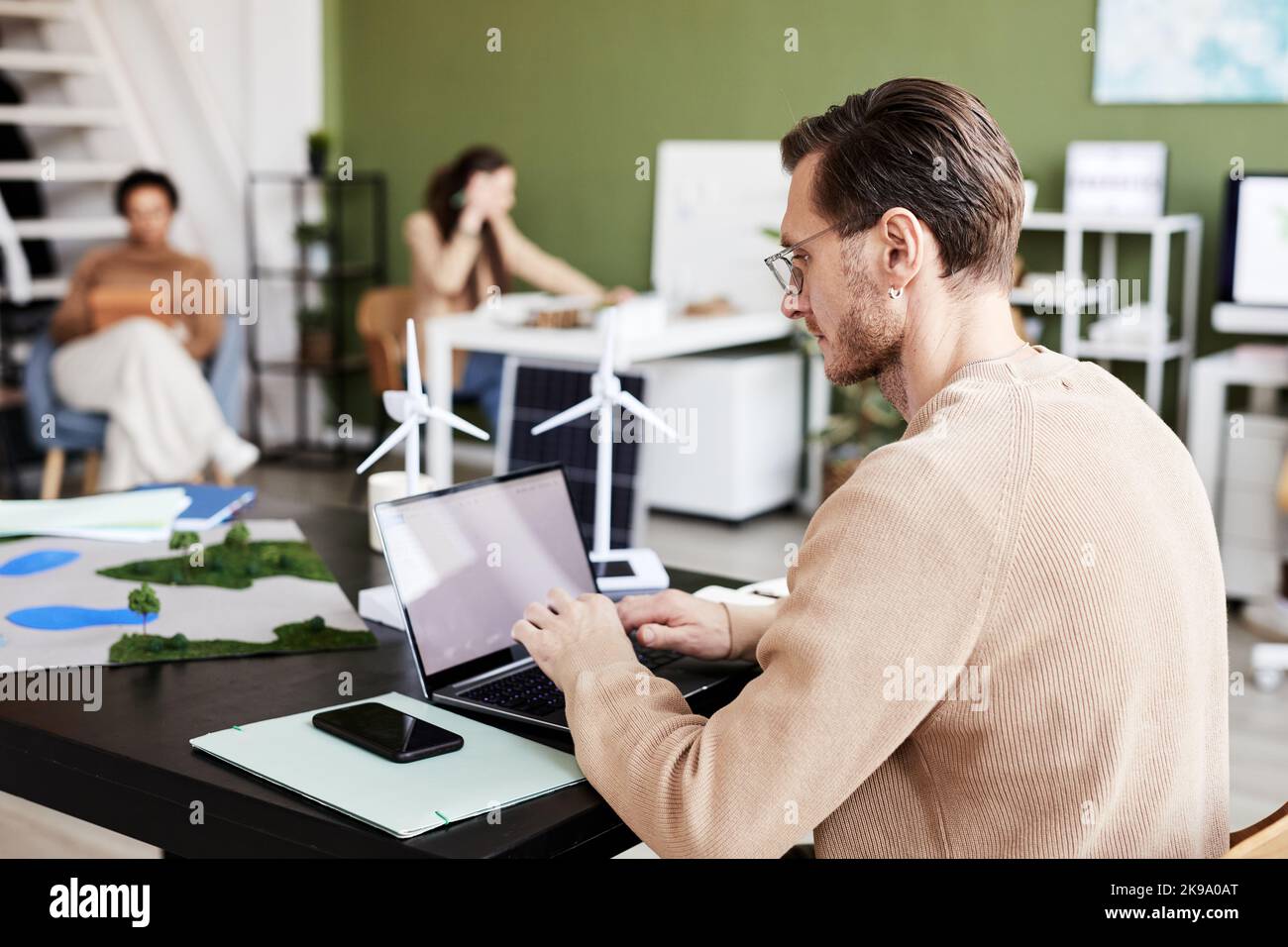 Young businessman in eyeglasses concentrating on his online work on ...