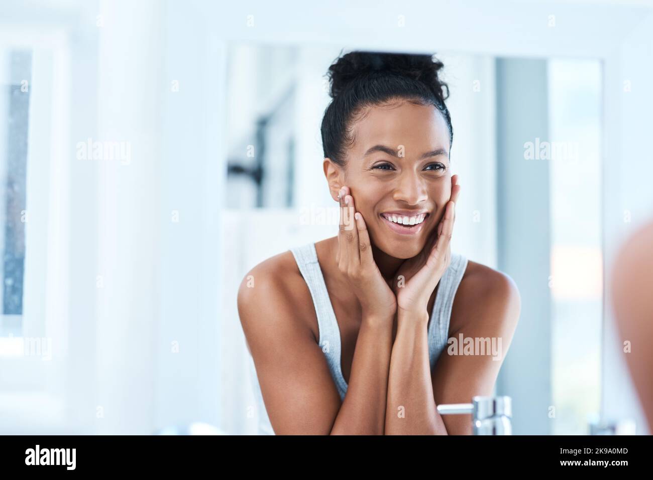 My skin looks and feels great. an attractive young woman touching her ...