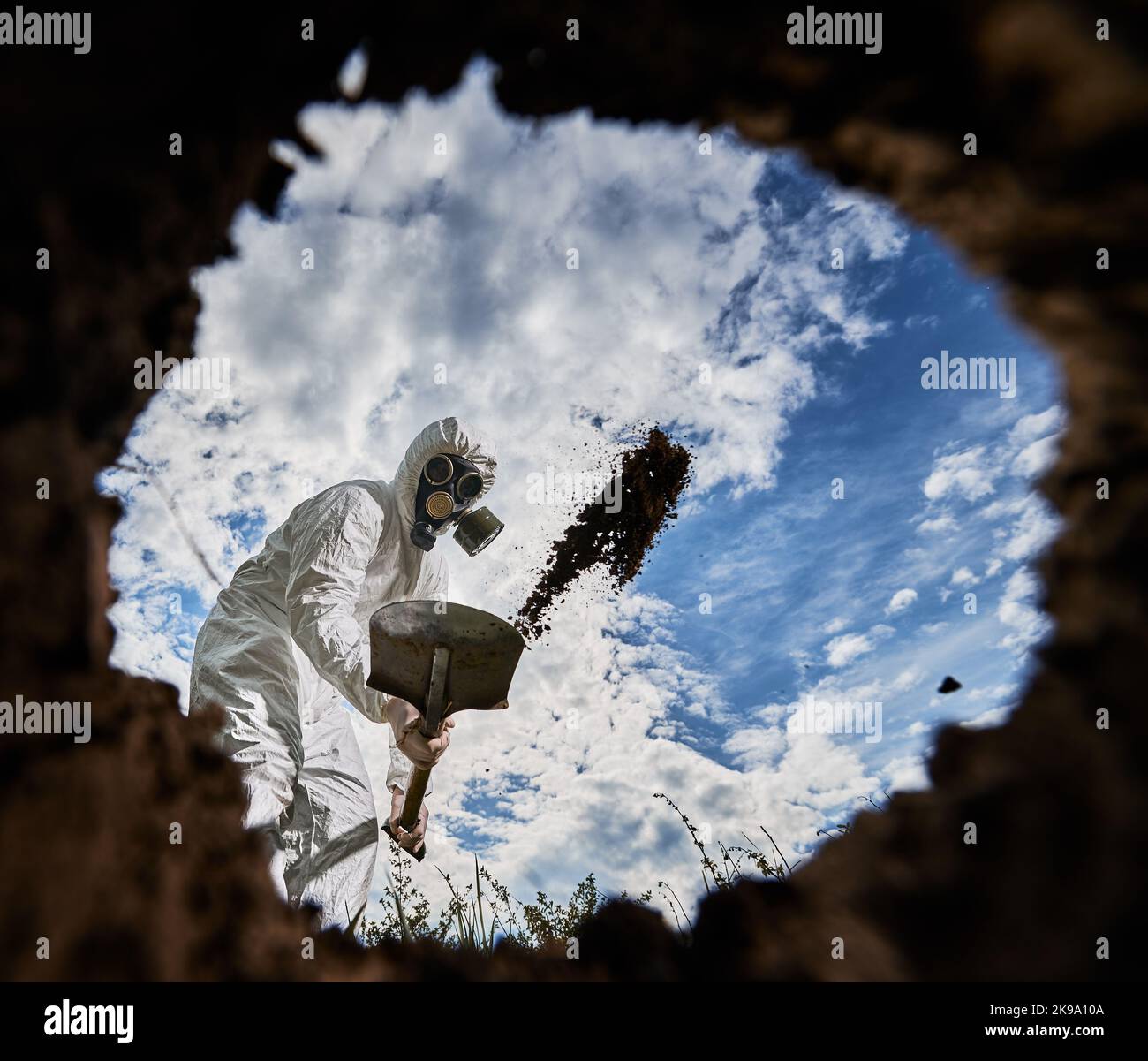 View from inside pit of man with gas mask in protective overalls ...
