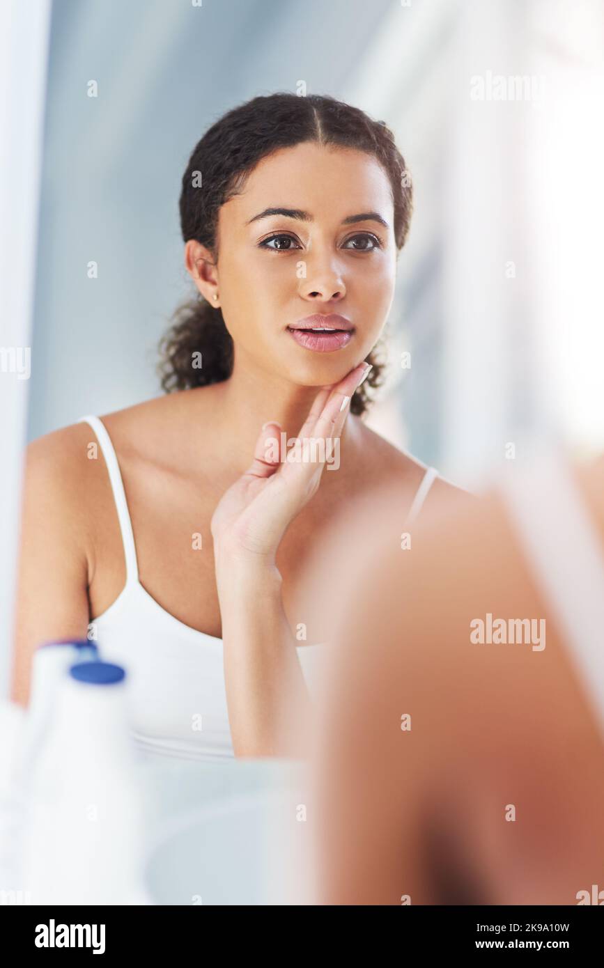 My skin is getting so much better. an attractive young woman touching ...