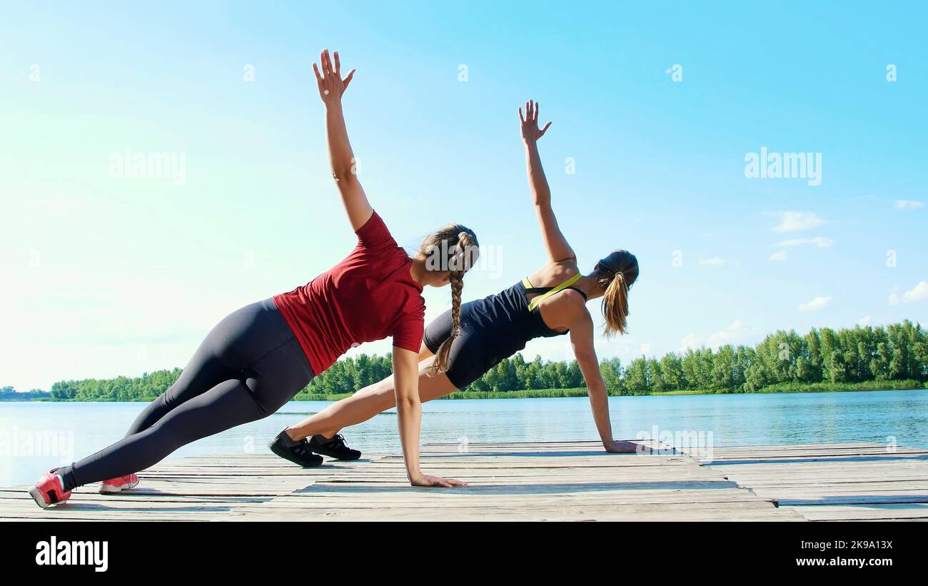 Two beautiful, athletic blonde women, doing coordination and balance ...