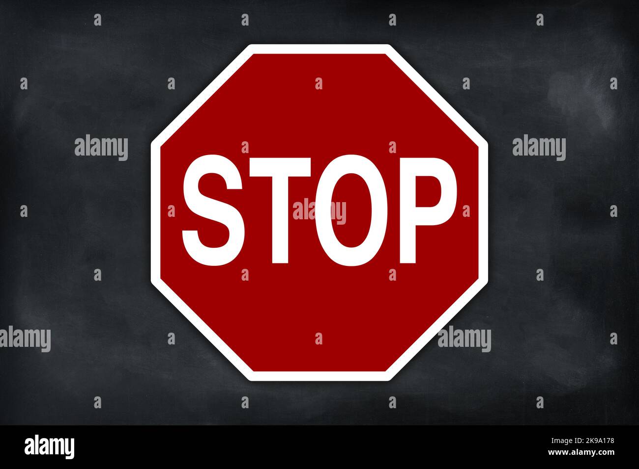 Red color stop sign on black chalkboard with empty space for text ...