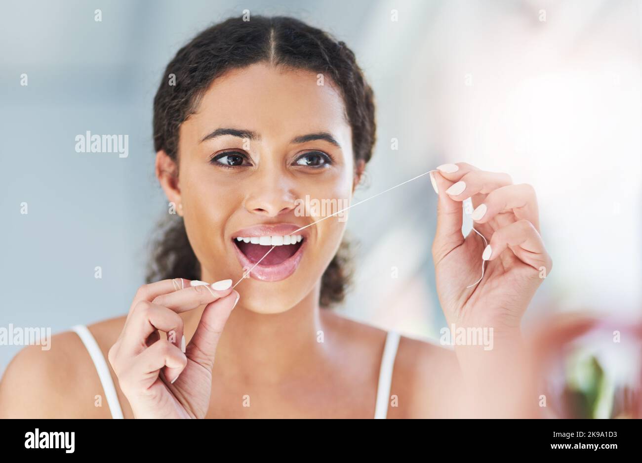 When you clean, do it properly. an attractive young woman flossing her ...